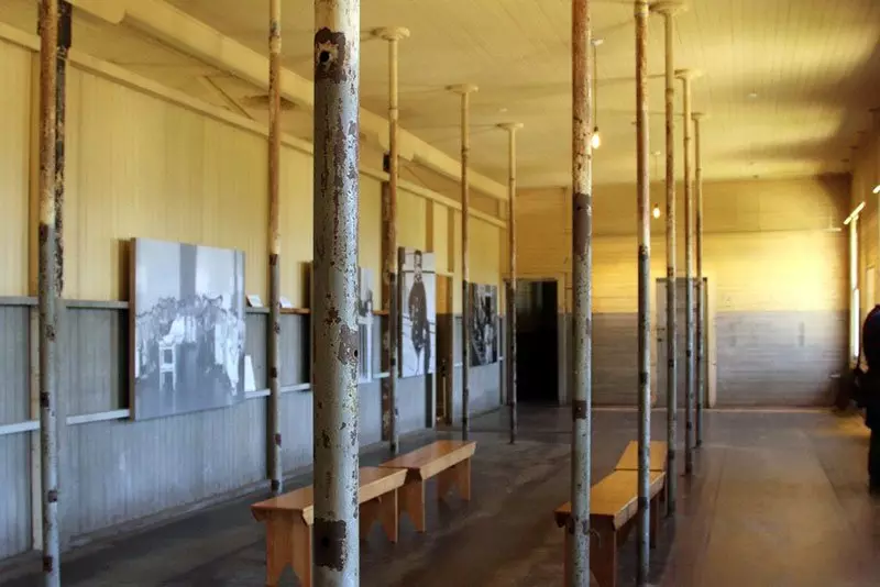 Large room inside the detention center, with enlarged archival photos hanging on one wall.