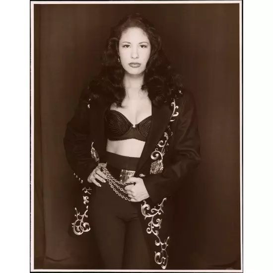 Černobílá fotografie Seleny v černých kalhotách a vyšívané bundě