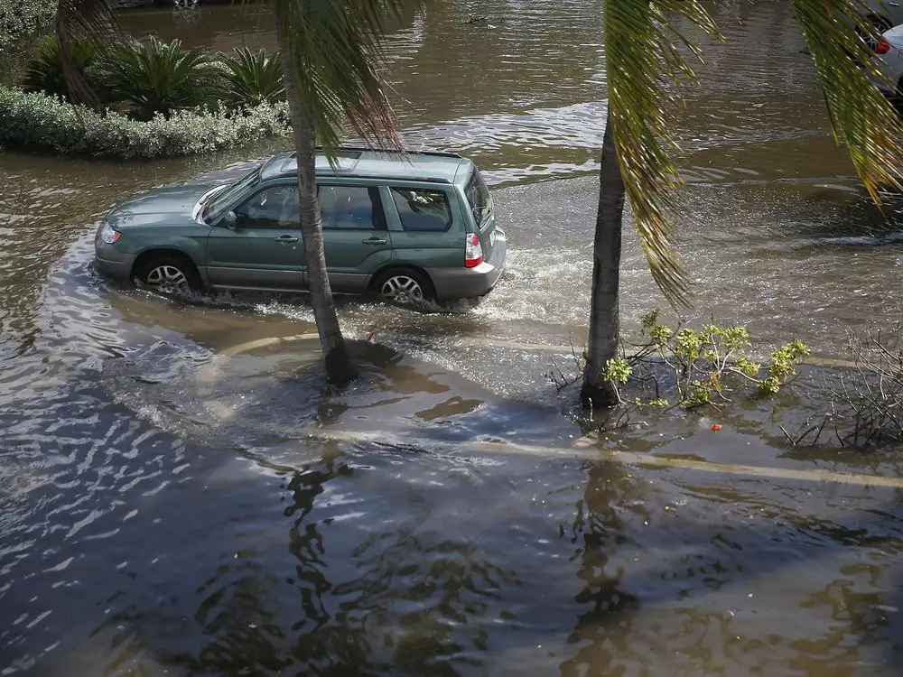 Vozidlo projíždí zaplavenými ulicemi způsobenými kombinací oběžné dráhy kolem Měsíce, která způsobila sezónní příliv a odliv, a to, čemu mnozí věří, je stoupající hladina moří v důsledku změny klimatu 30. září 2015 ve Fort Lauderdale na Floridě.