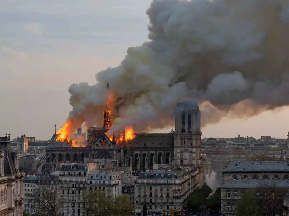 Ett tjockt moln av rök flyter upp från Notre-Dame-katedralen när det brinner, den 15 april 2019