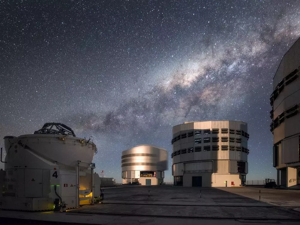 Tři z budov Very Large Telescope pod Mléčnou dráhou v noci