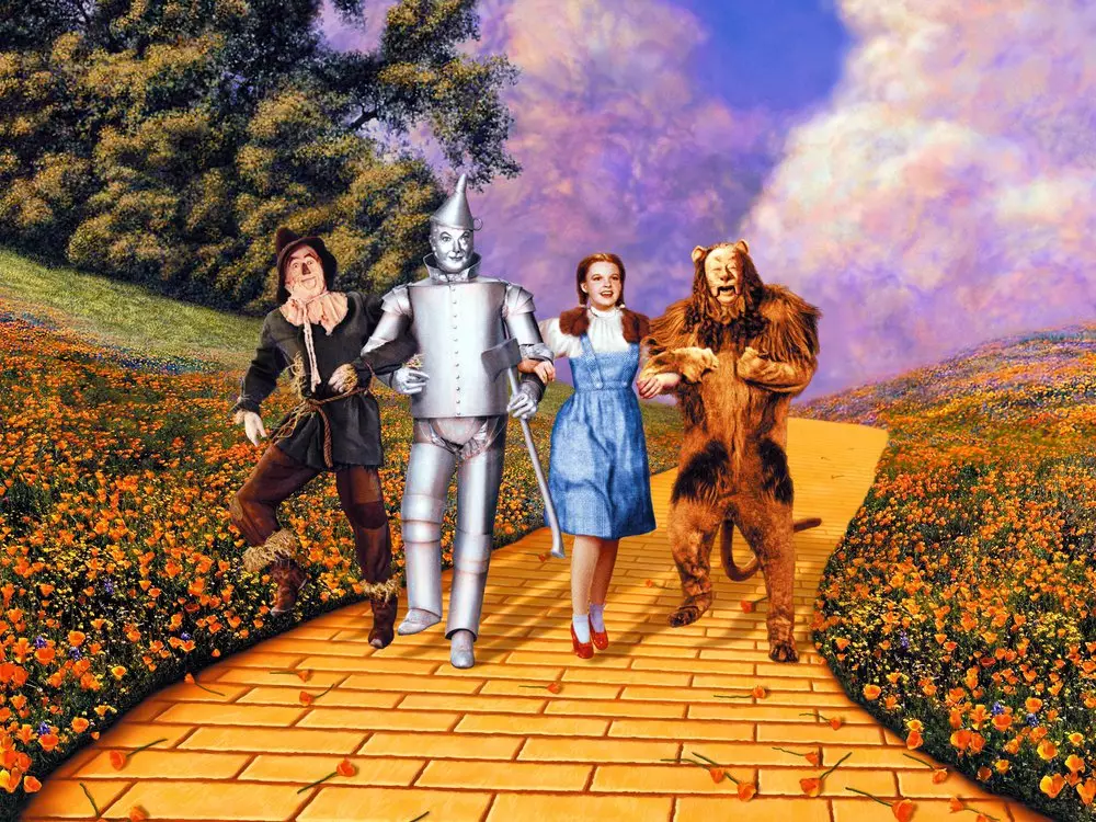 Empat orang, orang-orangan sawah, Manusia Timah, Dorothy dan seekor singa, berjalan bergandengan tangan di jalan bata kuning