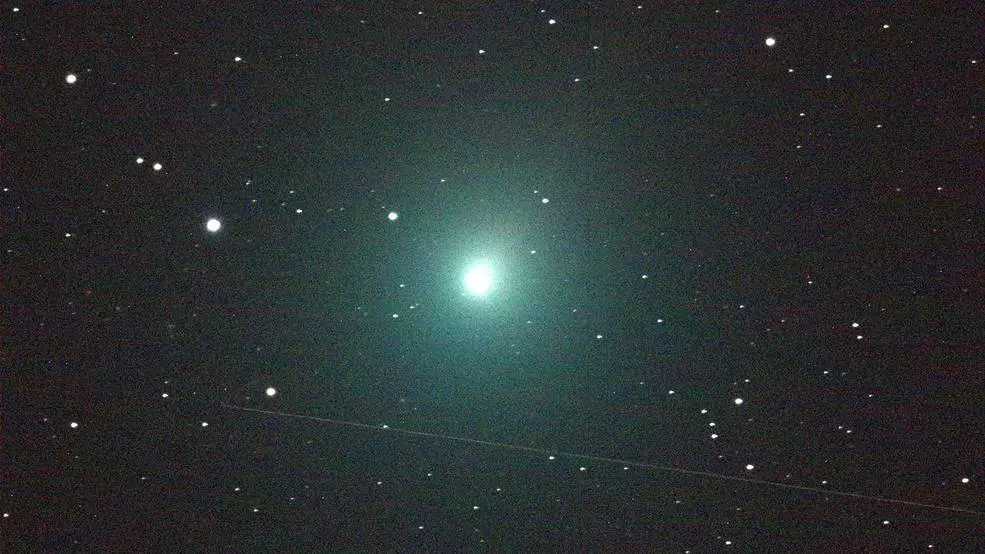 Daim duab ntawm Comet 46P / Wirtanen. Nyob rau hauv nruab nrab ntawm daim duab yog ib lub pob ntawm lub teeb uas glowing ci ntsuab tiv thaiv lub hnub qub dub ntuj.