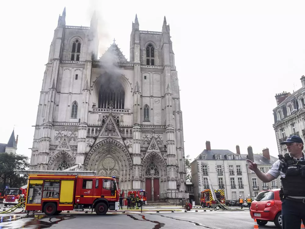 Katidira ni Nantes pẹlu ẹfin dudu, ọkọ ayọkẹlẹ onija ina ni iwaju