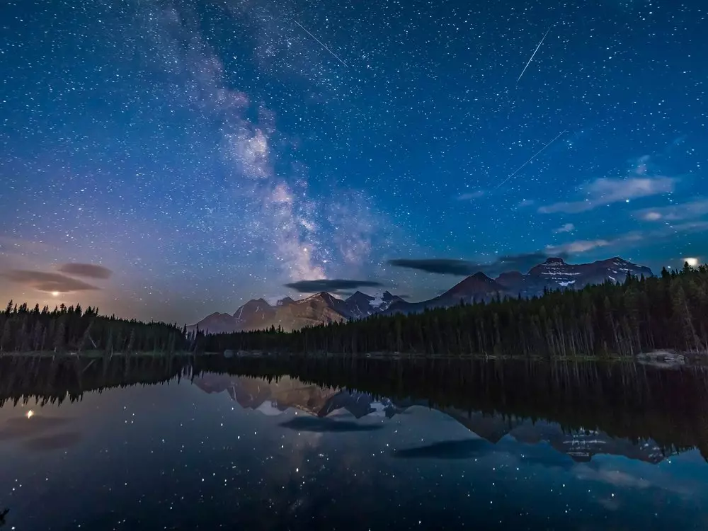 Pemandangan langit malam yang menghadap ke selatan di Danau Herbert, Taman Nasional Banff, Alberta, menunjukkan Bima Sakti di atas Kuil Gunung