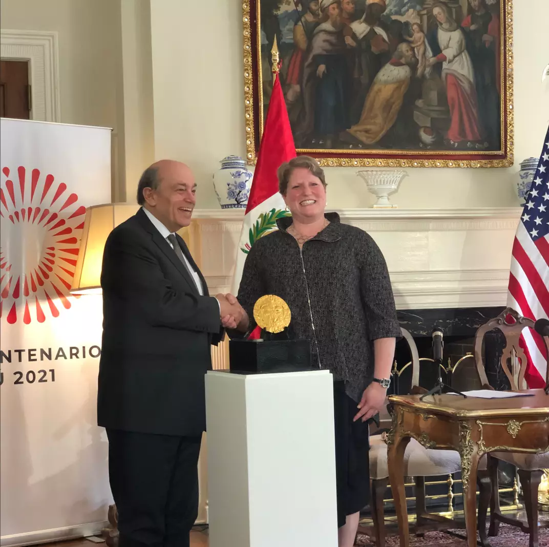 Hugo de Zela (maldekstre), perua ambasadoro en Usono, donas la manon al Amy Van Allen, projektestro en la Nacia Muzeo de la Usona Indiano de la Smithsonian, en ceremonio la 15-an de junio markanta la revenon de la Echenique Plake.