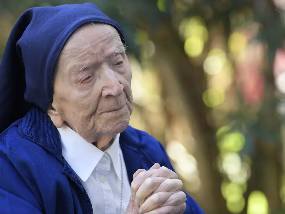 जन्म की रजिस्ट्री में बहन आंद्रे, ल्यूसिल रैंडन, सबसे बड़ी फ्रांसीसी और यूरोपीय नागरिक, अपने 117 वें जन्मदिन की पूर्व संध्या पर व्हीलचेयर में प्रार्थना करती हैं