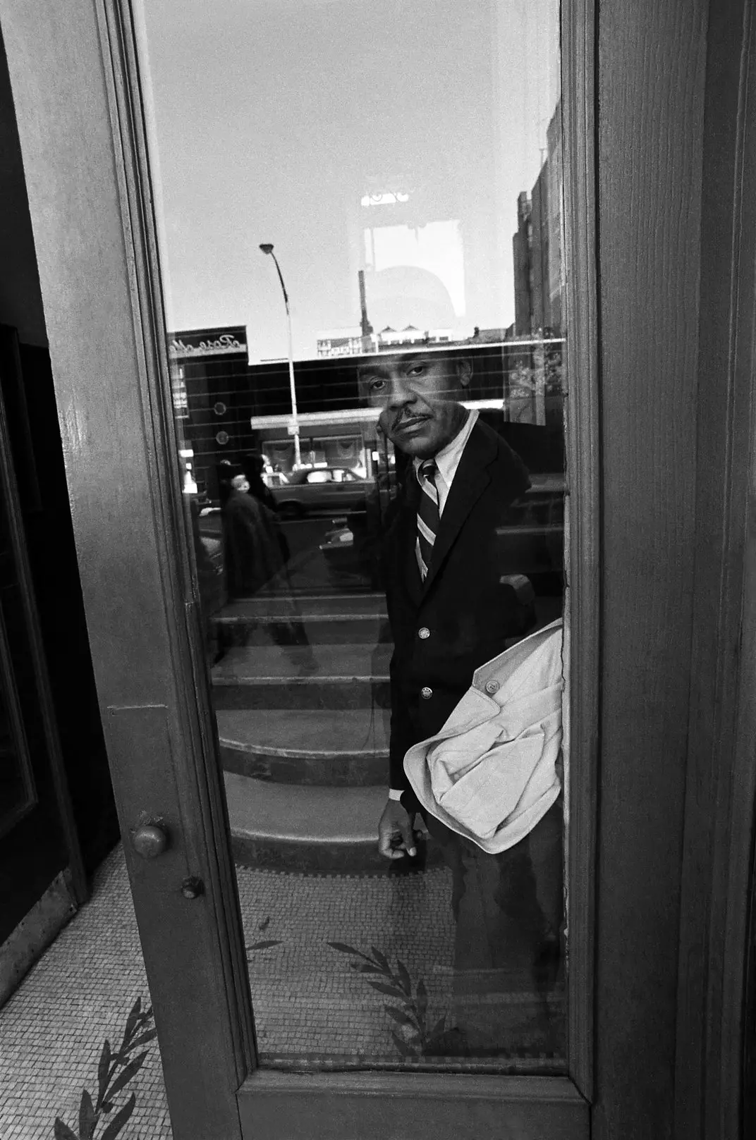 Portrét Ralpha Ellisona za skleněnými dveřmi