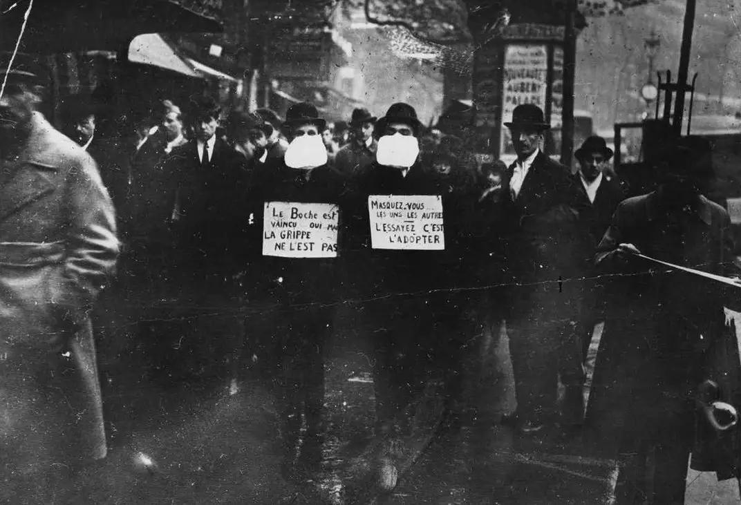 1 maart 1919: Twa manlju drage en pleiten foar it brûken fan grypmaskers yn Parys tidens de grypepidemy fan 1918.
