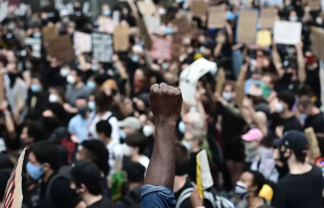 Un bărbat ridică pumnul la protestul Black Lives Matter