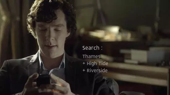 Benedikts Kamberbačs kā Šerloks Holmss, kurš savā mobilajā tālrunī meklē pavedienus
