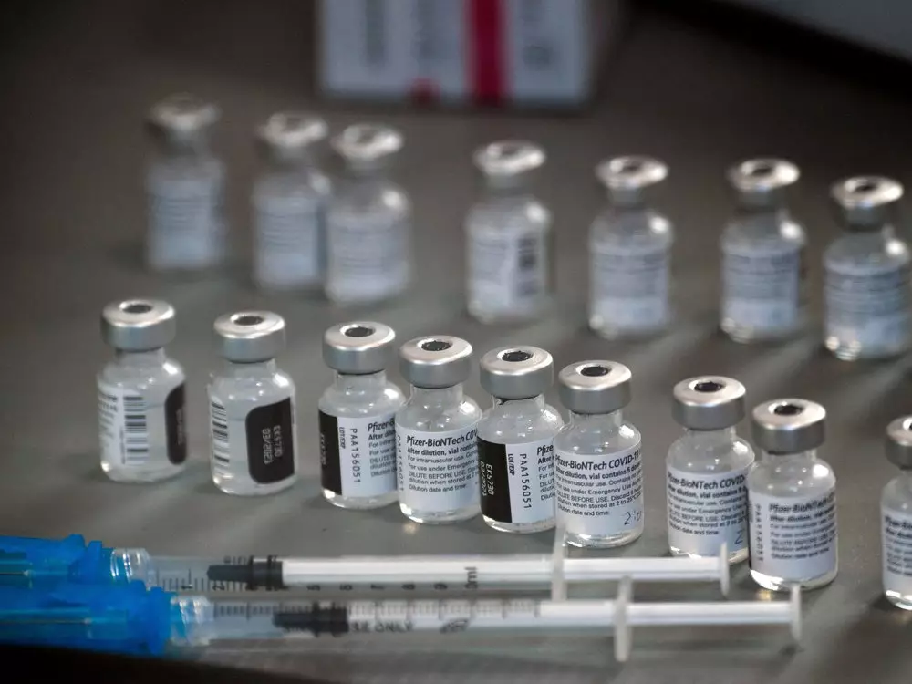 O fotografie cu flacoanele și seringile de vaccin Pfizer