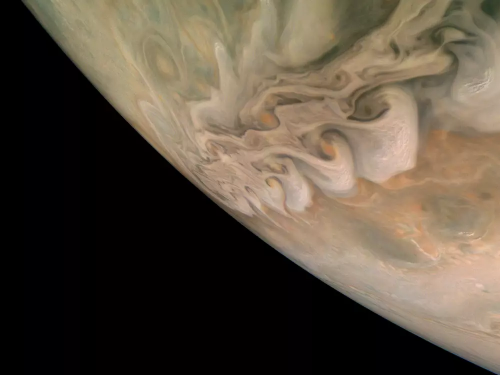 Valokuva Jupiterin pyörteistä pilvistä ja planeetan horisontin käyrästä
