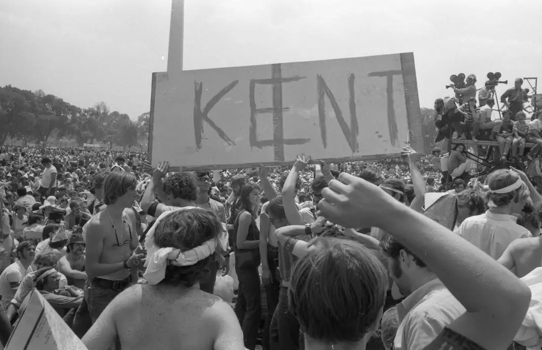 протестующие на Национальной аллее, один из них держит табличку с надписью «Кент».