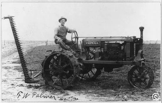 חקלאי אמריקאי המפעיל טרקטור וקוצר