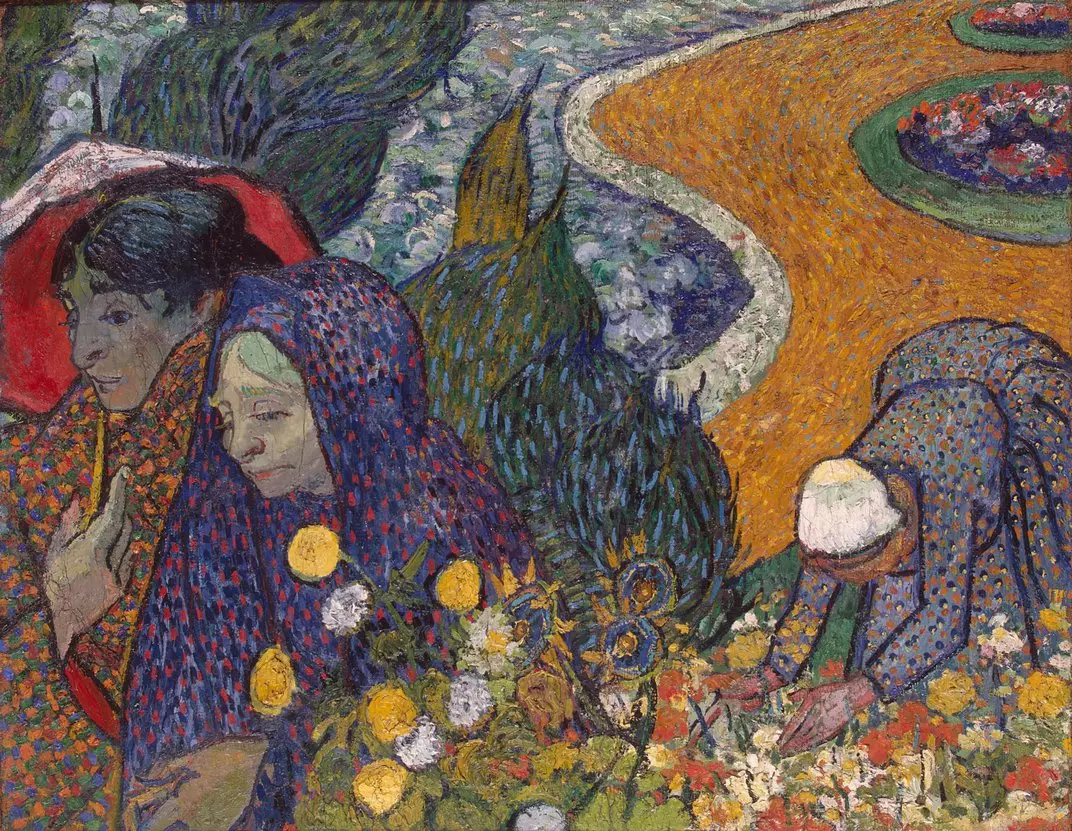A young woman with dark hair and an older woman with a dark purple shawl walk through a field, with cypress trees in the background and a woman bending down to tend to flowers in the garden