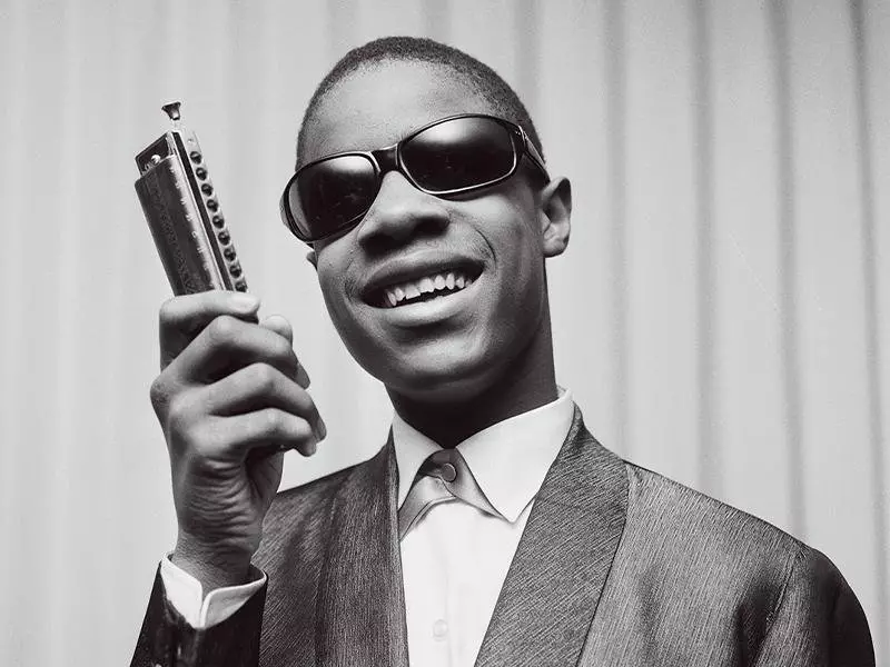 Stevie Wonder hält eine Mundharmonika