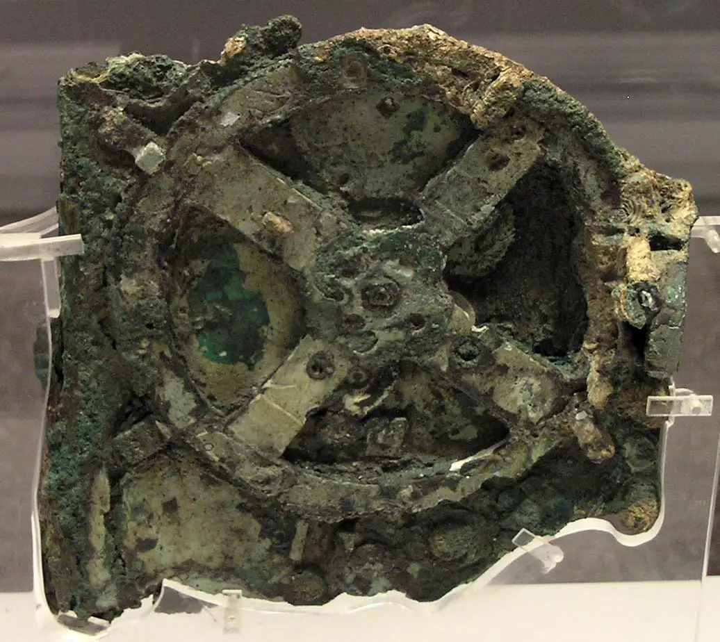 Një pajisje e ndryshkur, e gjelbër, e degraduar në formën e një X me një rreth rreth tij, e ekspozuar në një muze