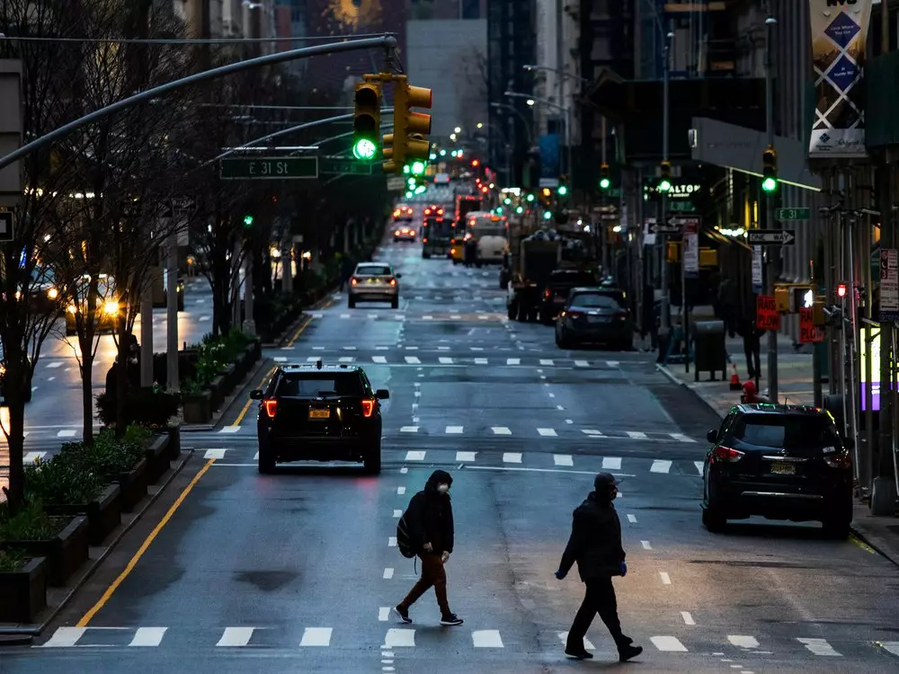 مردم پس از اینکه اعلام شد برخی از خیابانها در واکنش به شیوع ویروس کرونا در 27 مارس 2020 در شهر نیویورک بسته خواهند شد، از خیابان پارک عبور میکنند.