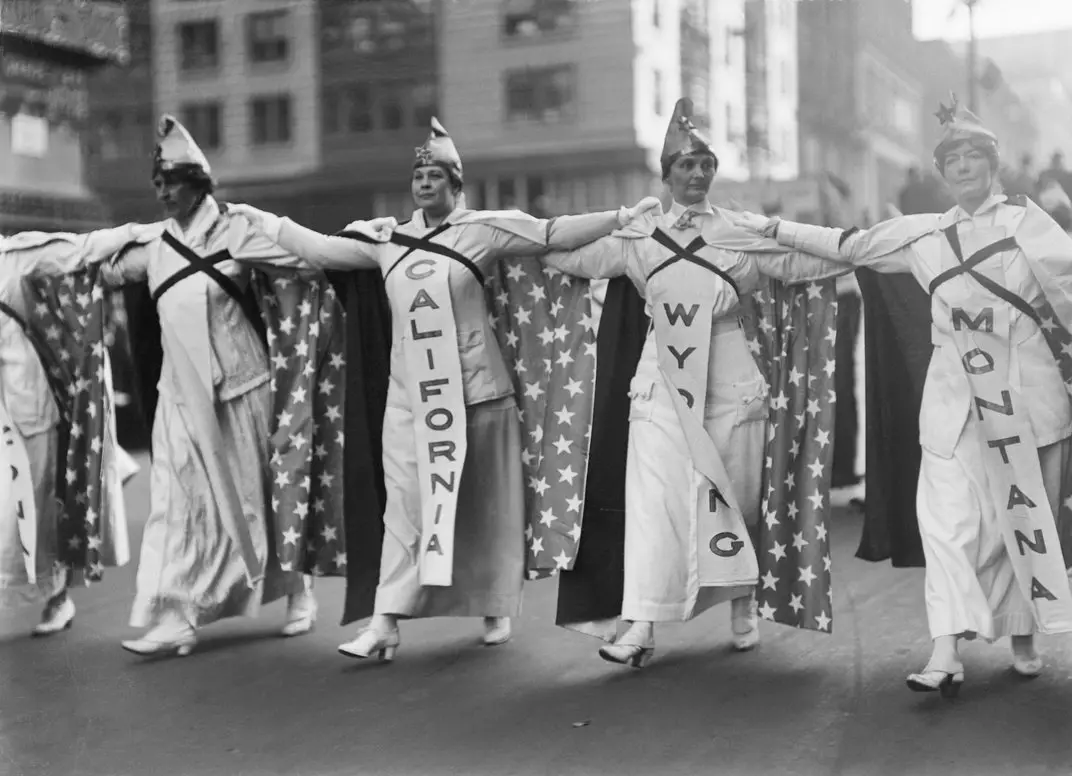Kobiety noszące kostiumy czytające California, Wyoming i Montana idą ulicą Nowego Jorku w paradzie sufrażystek