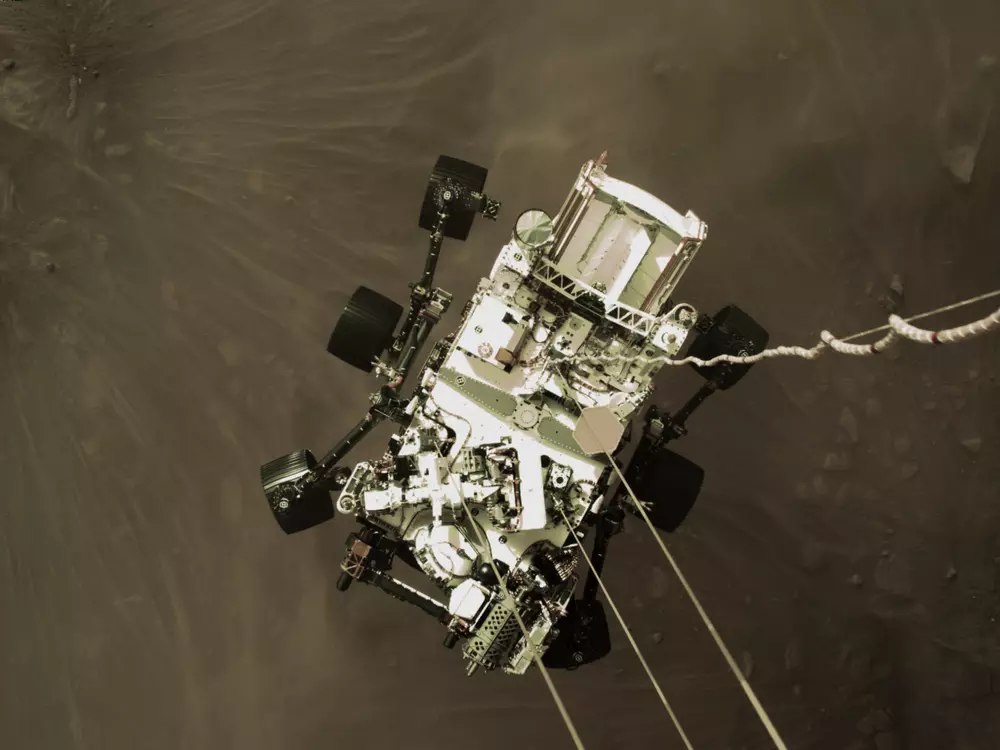 Ein Foto, das während der Landung von Perseverance aufgenommen wurde, zeigt, wie es an Schnüren über der Marsoberfläche baumelt