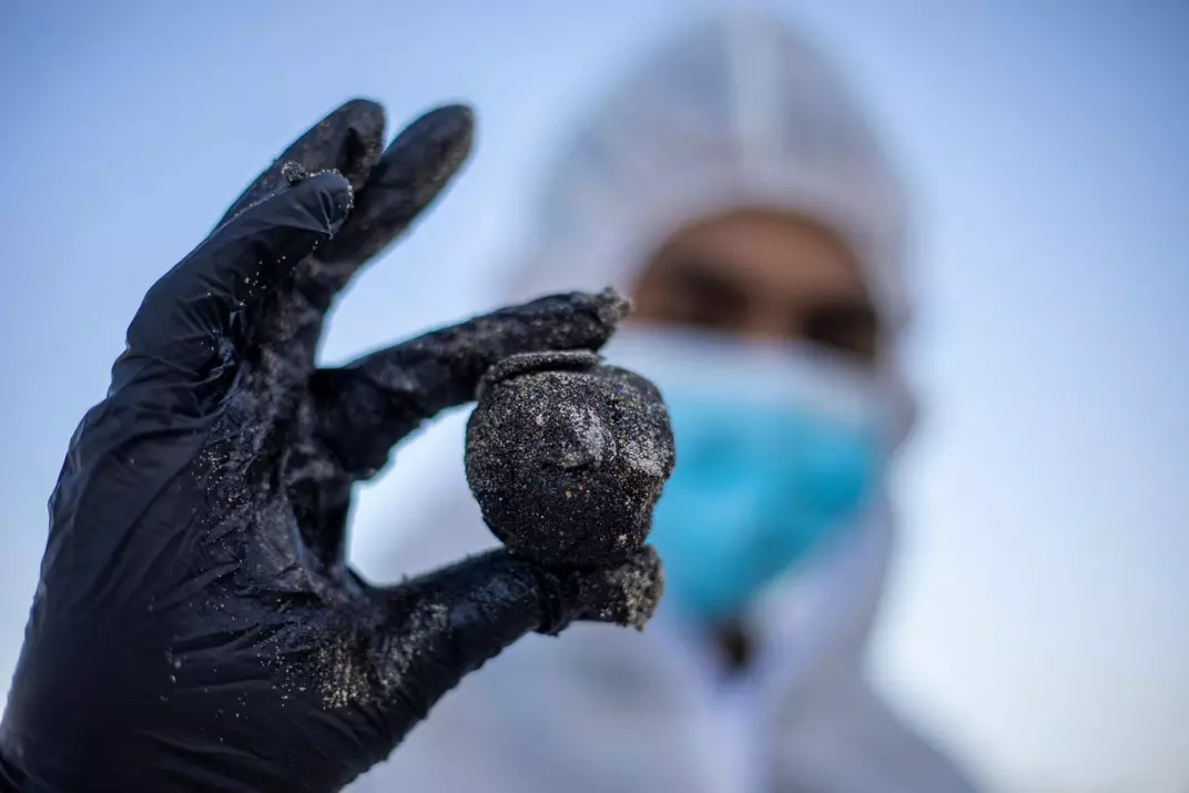 Israeli soldier holds a ball of tar 