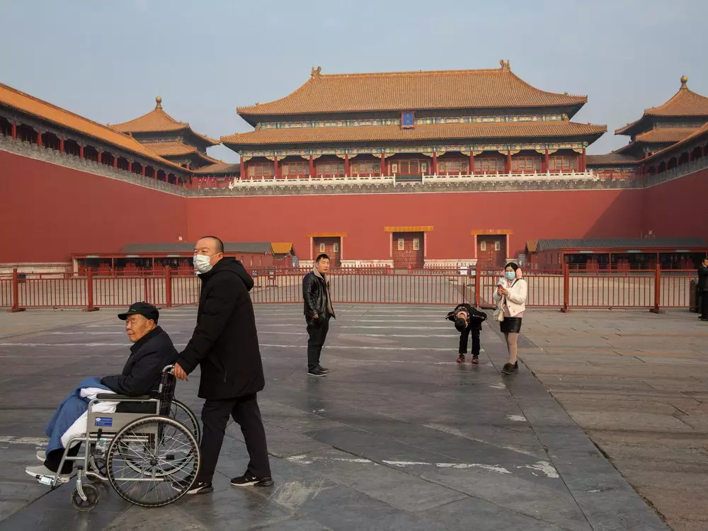 Žmonės eina pro uždarytą Uždraustojo miesto įėjimą Pekine.
