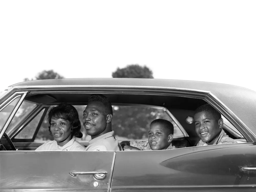 Семејство од 1960-тите седи во седан автомобил со четири врати