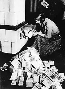 bahan bakar murah. Seorang wanita Jerman menyalakan ketelnya dengan gumpalan uang kertas miliaran, musim gugur 1923.