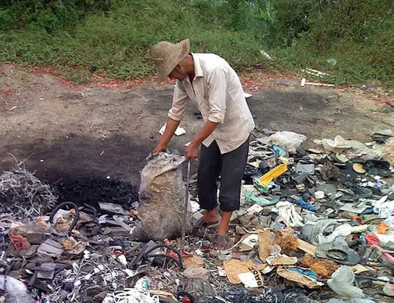 دۇنيادىكى ئەڭ چوڭ ئېلېكترونلۇق تاشلاندۇق مەركىزى گۈييۇدىكى بىر ئەر ئەخلەتلەرنى رەتلەيدۇ.