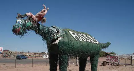 Ee vun den traureg Dinosaurier am Stewart's Petrified Wood bei Petrified Forest National Park an Arizona.