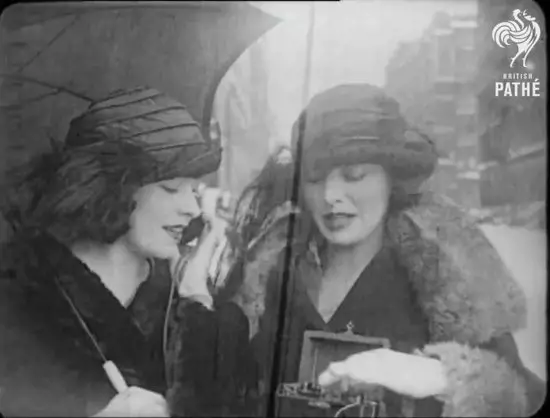 휴대용 수정 라디오를 조작하는 1922년 영화 "Eve's Wireless"의 두 여성