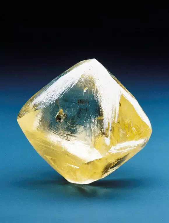 Un diamante amarillo pálido sobre un fondo verde azulado.