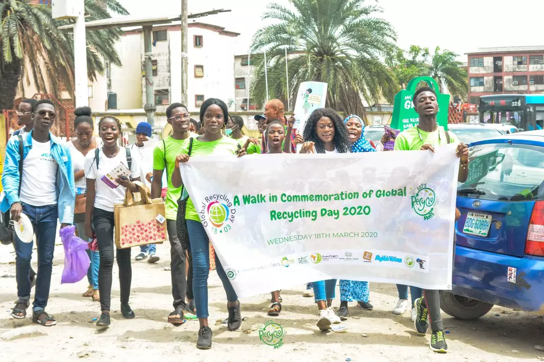 students walk together holding a banner for World Recycling Day