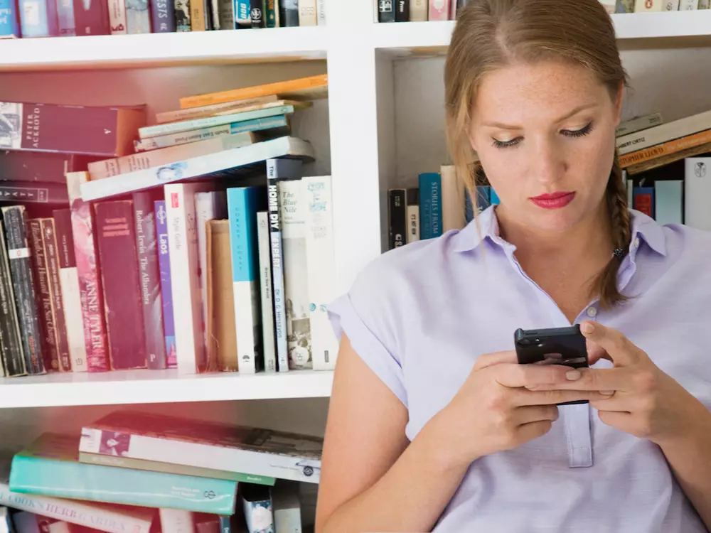 Frau SMS in Bibliothek