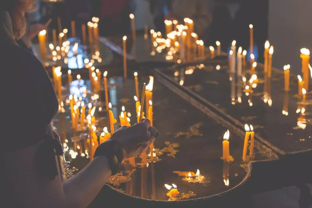Зажженные свечи в церкви на темном фоне