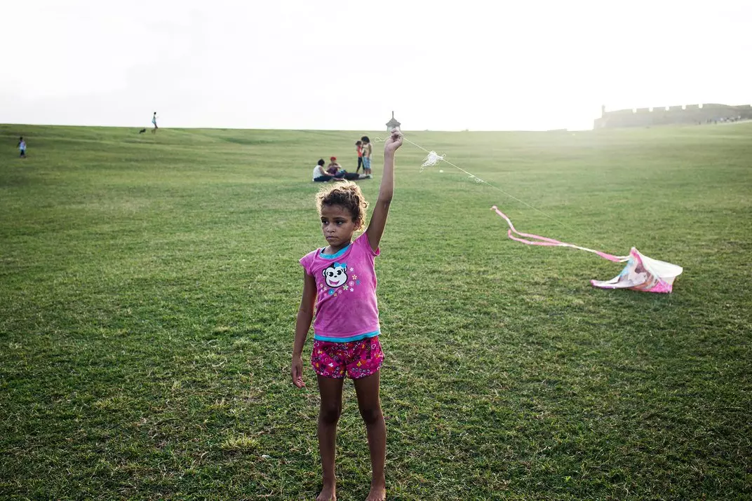 In lyts famke mei de namme Brenda fljocht in kite by El Morro fort by San Juan Harbor.