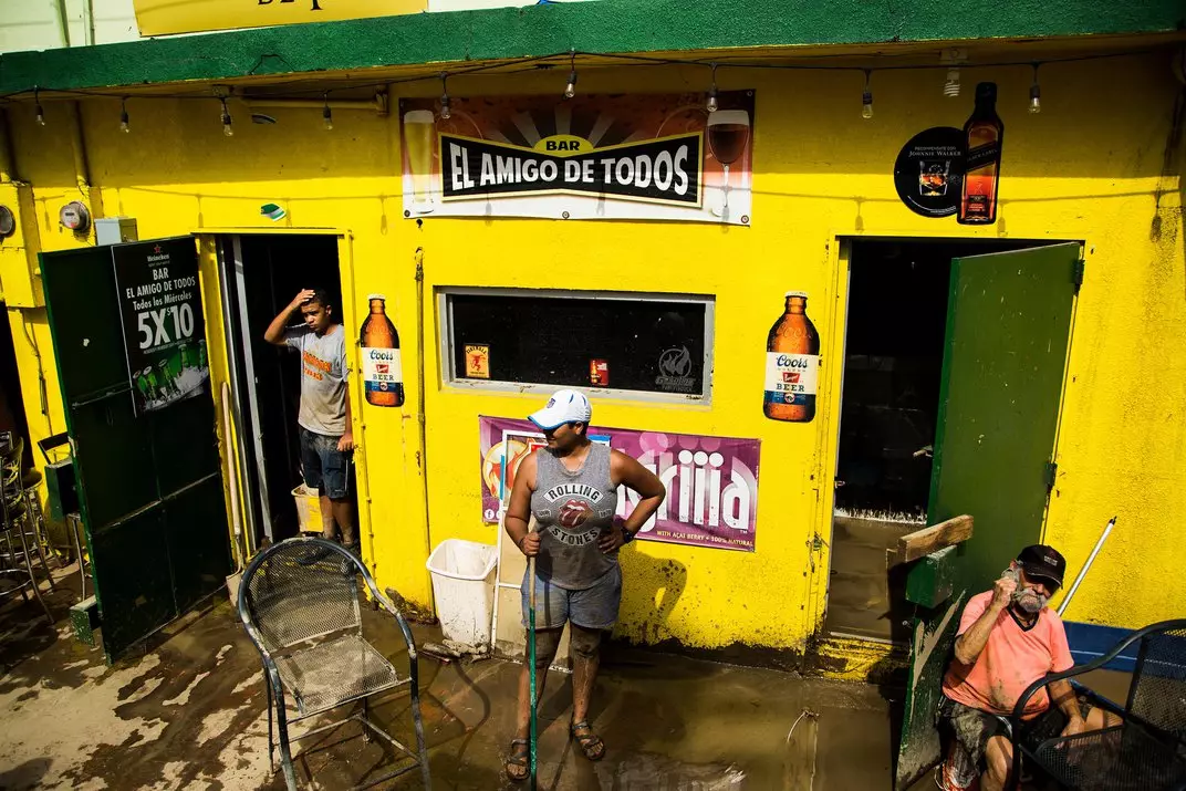 Werknemers maken een bedrijf schoon dat onder water kwam te staan in Toa Baja, aan de noordkust van Puerto Rico.