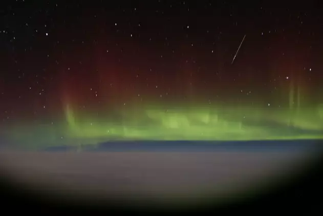 Šiaurės pašvaistė matoma iš lėktuvo su meteoru