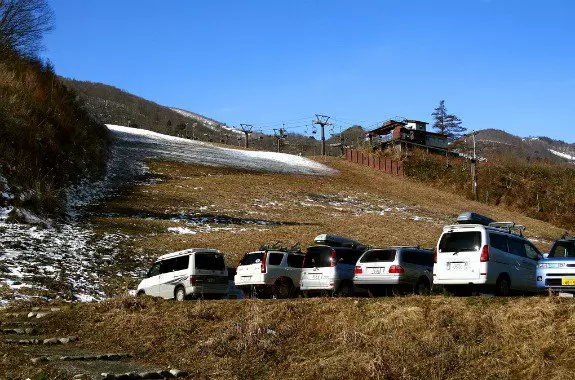डिसेम्बर 2006 मा हिउँले लगभग शून्य भएको जापानी स्की ढलानमा कुर्सी लिफ्ट झुन्डिएको छ।