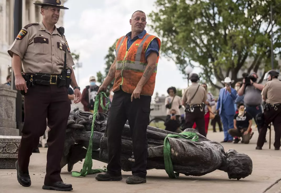 Ein Arbeiter bereitet den Abtransport der umgestürzten Columbus-Statue vor