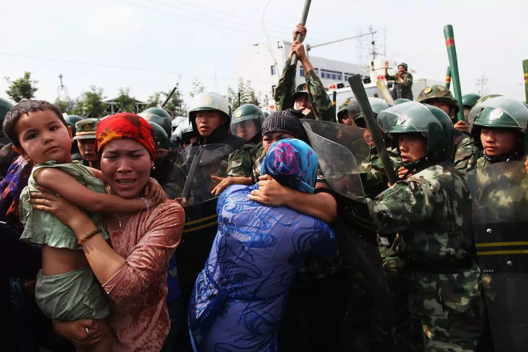 Polícia e manifestantes em Urumqi durante os distúrbios étnicos de julho de 2009