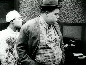 Buster Keaton jako lékař (všimněte si jeho krví potřísněné haleny) a Arbuckle jako potenciální pacient ve filmu Dobrou noc, sestro.
