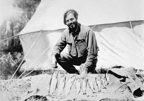 Ернест Хемингвеј позира за фотографију испред шатора