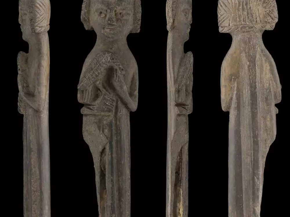 figure en bois sculpté d'une personne avec couronne et faucon sur le bras droit