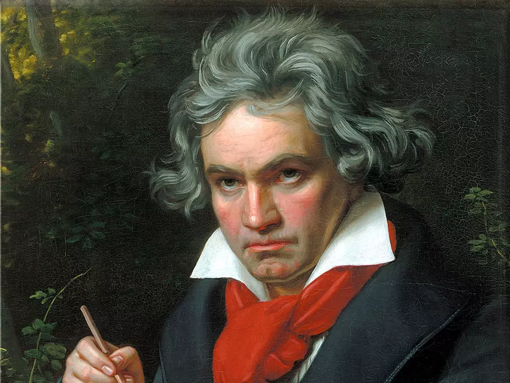 Ein Porträt von Beethoven, einem weißen Mann mit rötlichen Wangen, der eine Partitur und einen Bleistift in der Hand hält, einen roten Schal um den Hals trägt, mit zerzausten, widerspenstigen Haaren