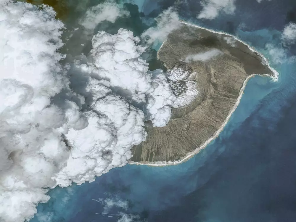 Satellitebild vu klenger vulkanescher Insel déi Damp spuet