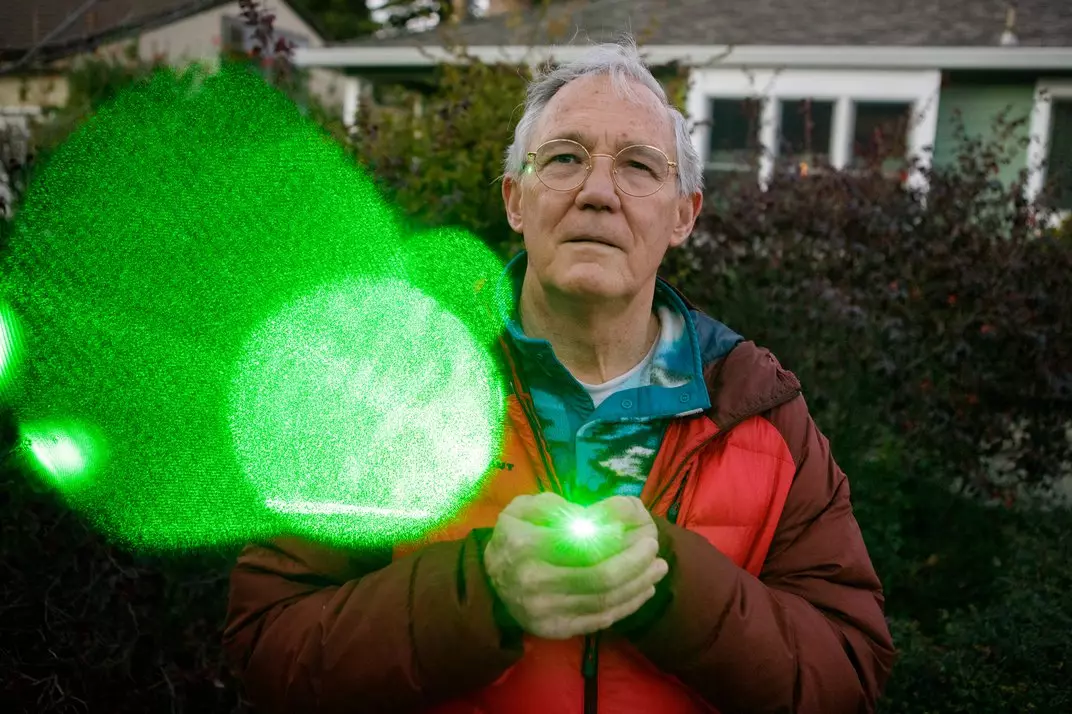 En mann holder en grønn laser