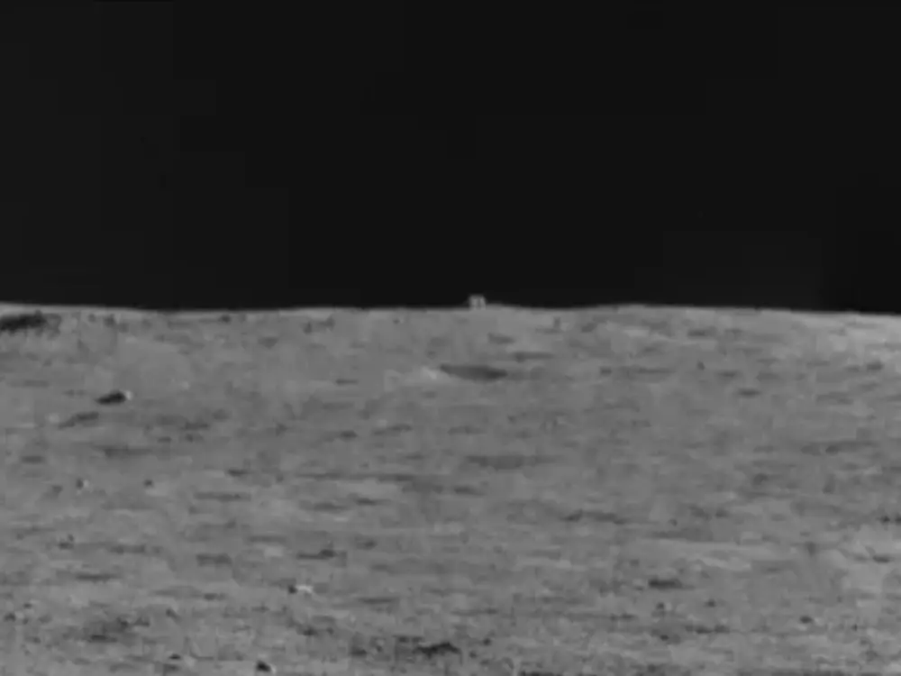 Melnbalti Mēness virsmas attēli ar nelielu kubveida objektu pie horizonta